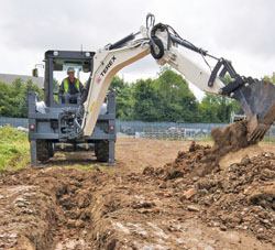Backhoe loader with curved boom| Concrete Construction Magazine